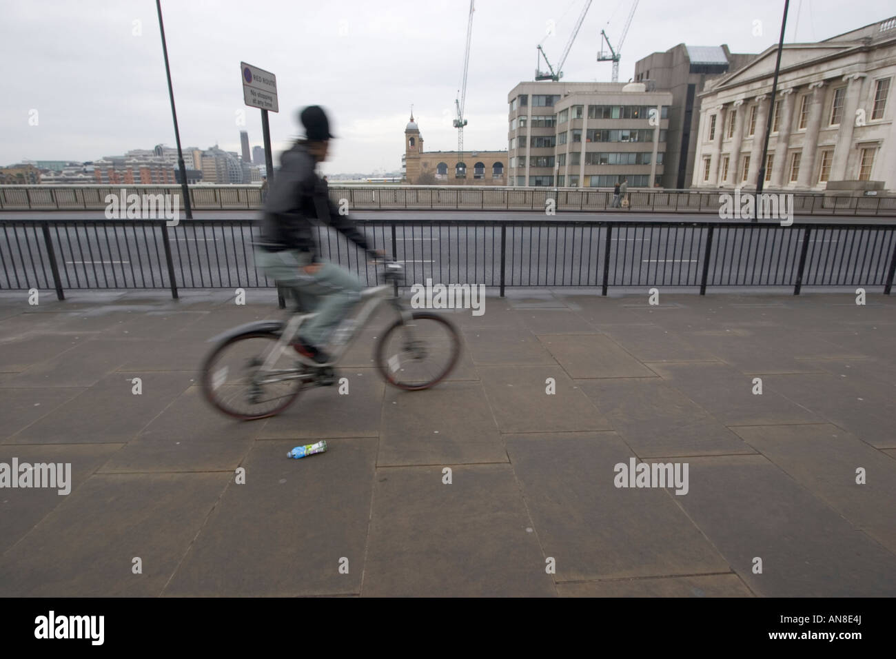 cyclist breaking law by cycling on the pavement on London bridge riding ...