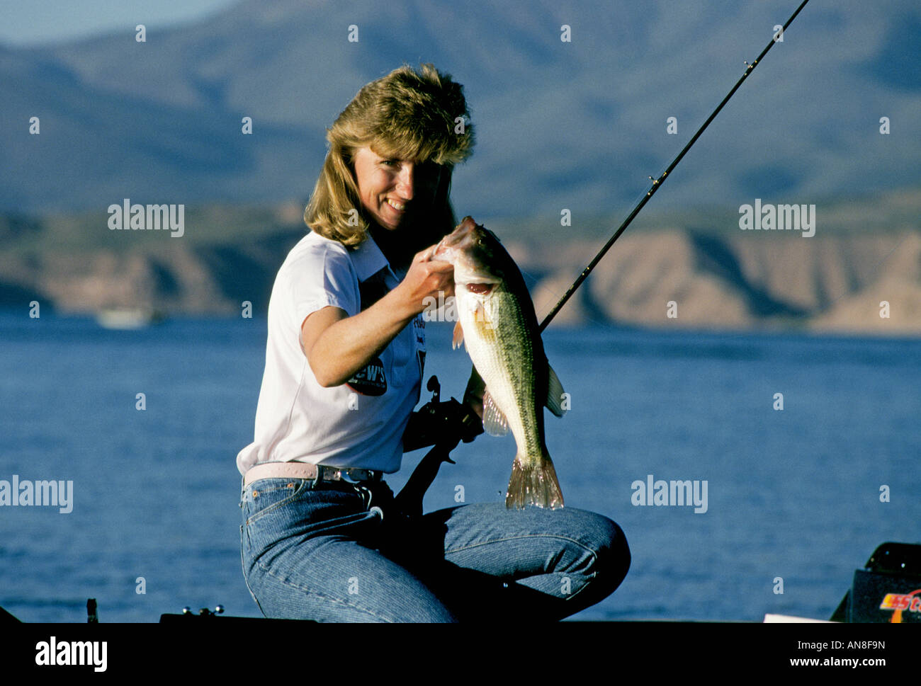 A woman bass fisherman angler in an expensive bass boat fishes for ...