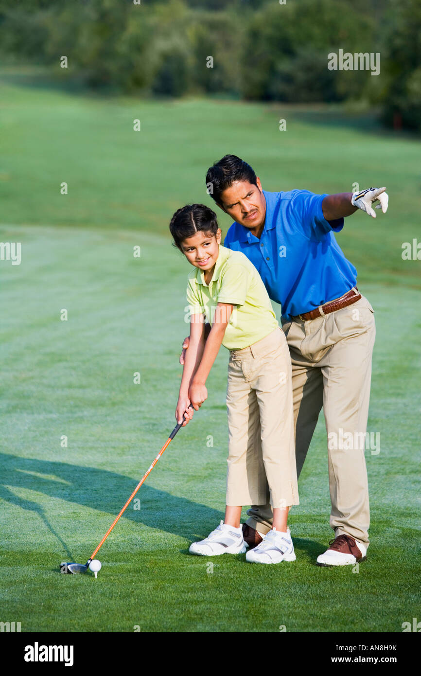 Hispanic father helping daughter play golf Stock Photo - Alamy