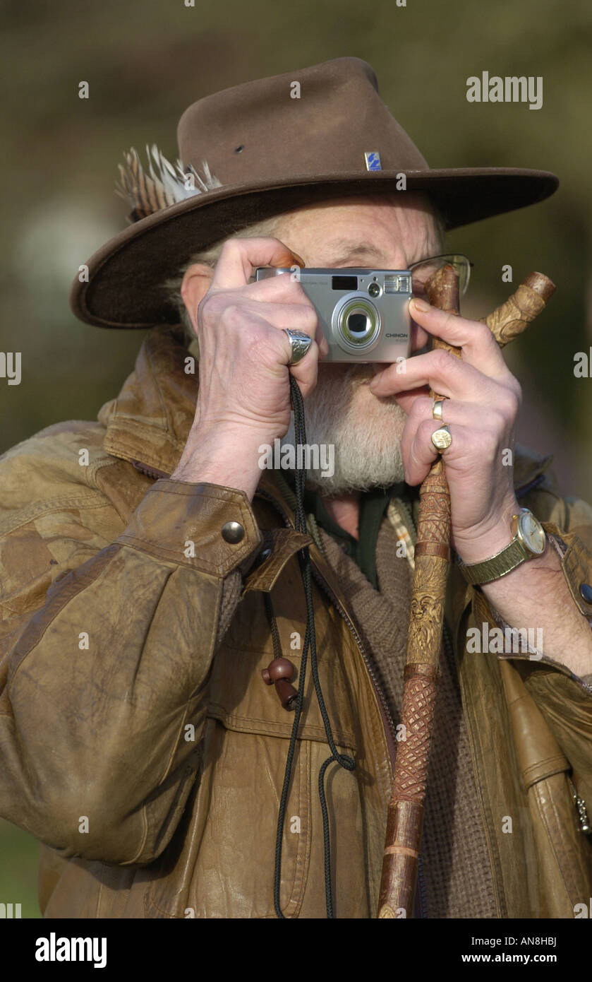 A rural walker takes a photograph while holding his walking stick Stock ...