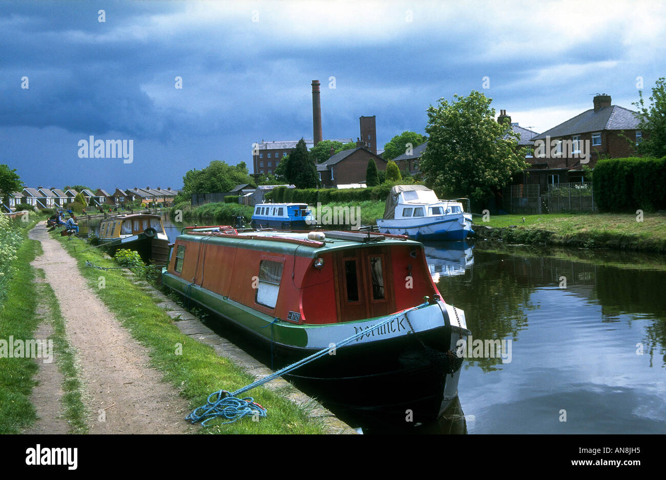 Canal boats and houses line the Leeds and Liverpool canal at Burscough ...