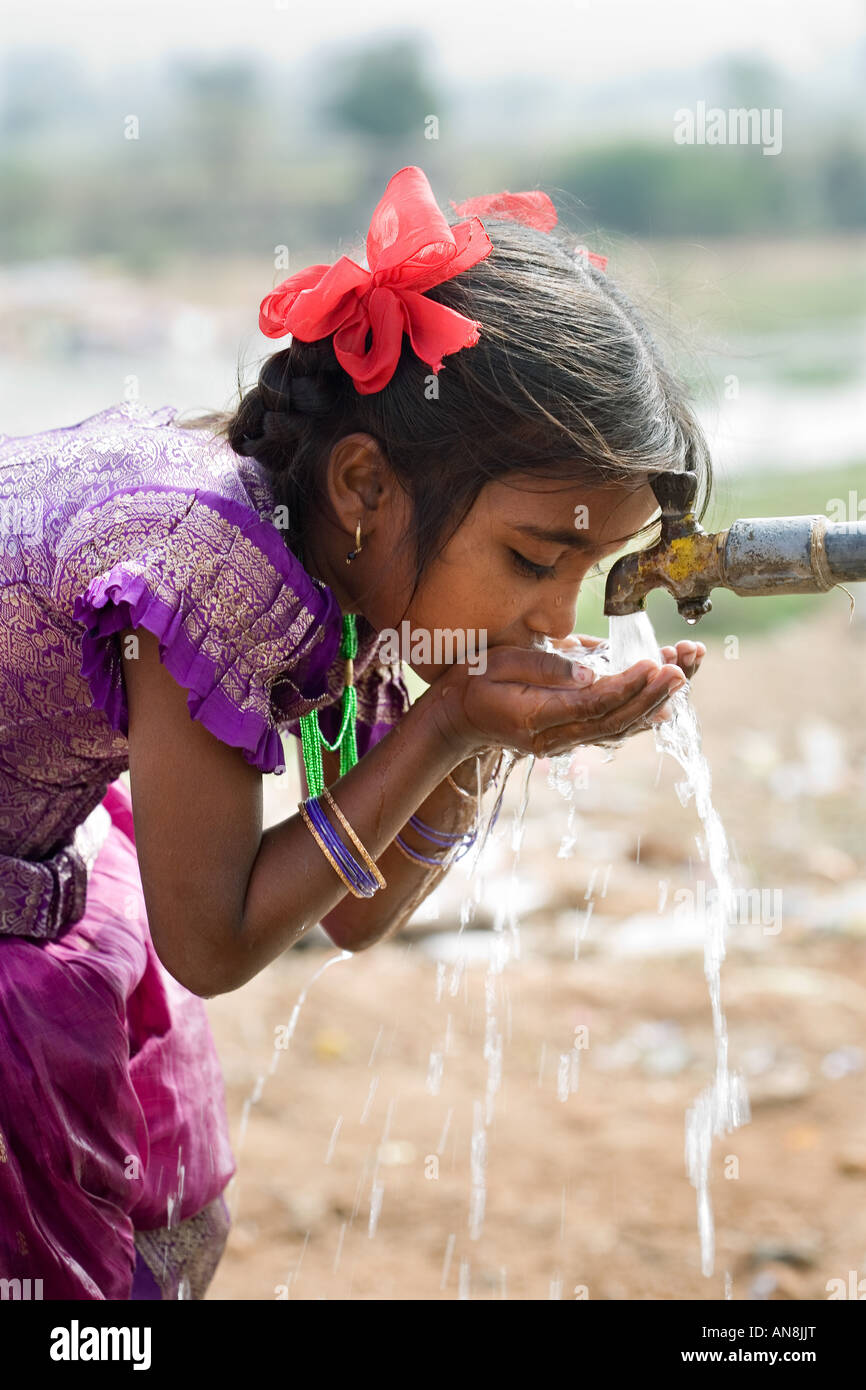 Indian girl drinking from water tap. Puttaparthi, Andhra Pradesh, India ...