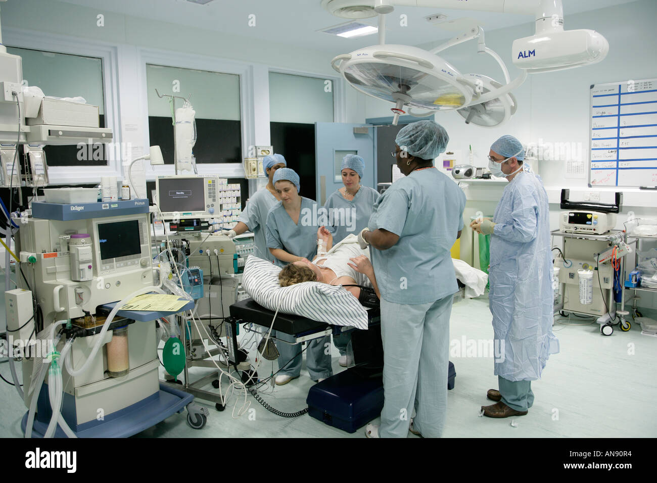 A woman receiving an injection into the spine in theatre before ...