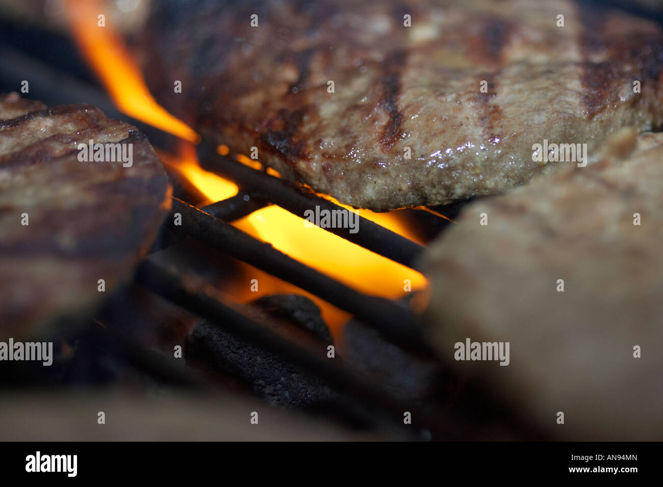partially cooked beefburgers on bbq grill with flame Stock Photo - Alamy