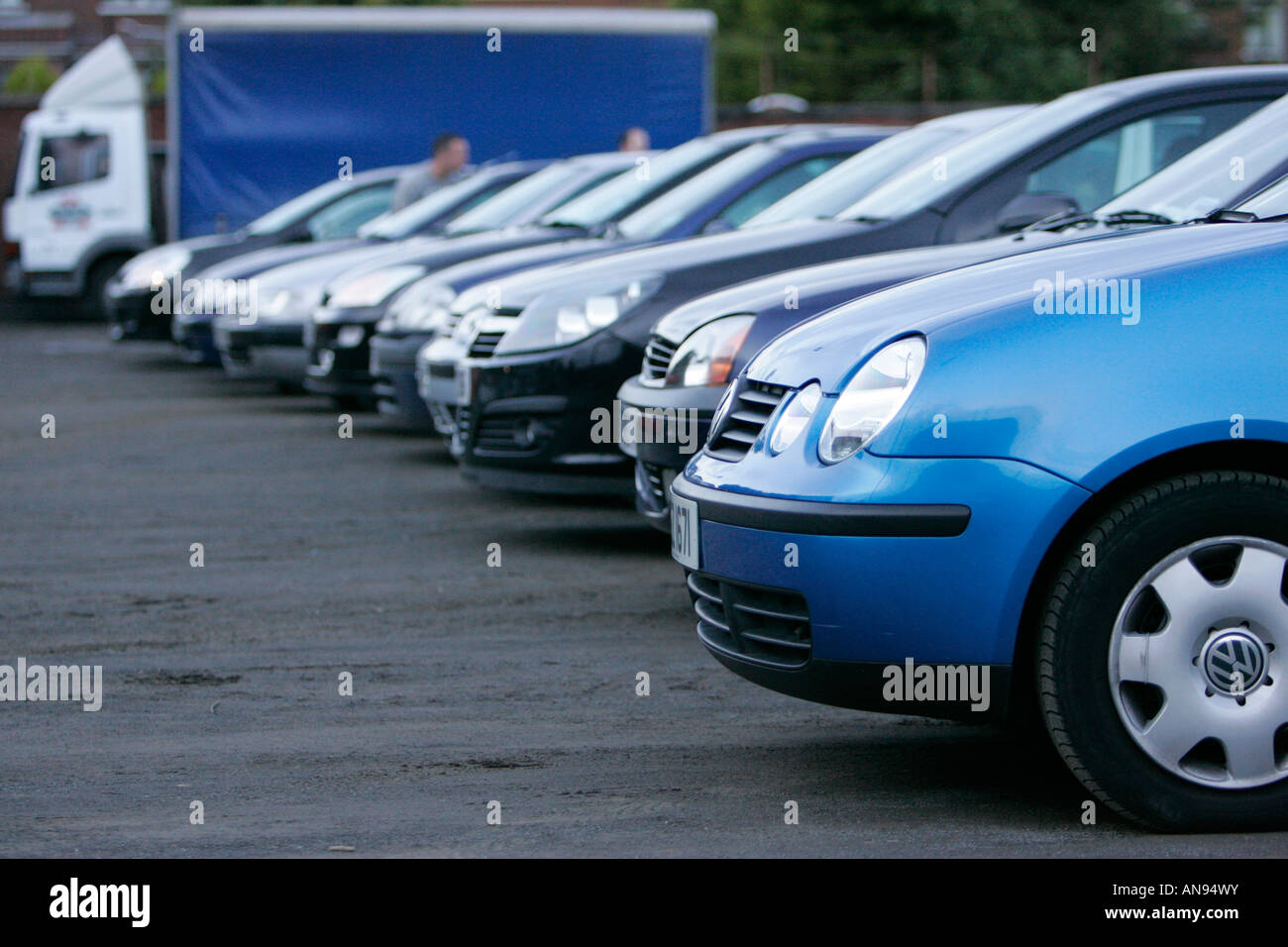 row of cars parked in a line late evening Stock Photo - Alamy
