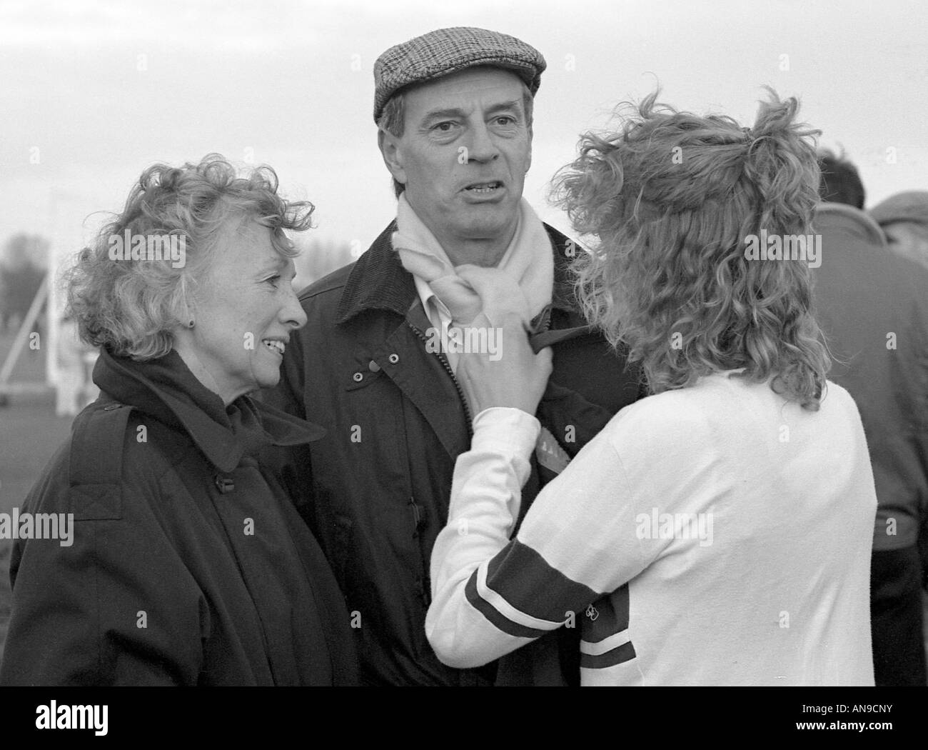 Three people holding discussion in cold weather at cross country race ...