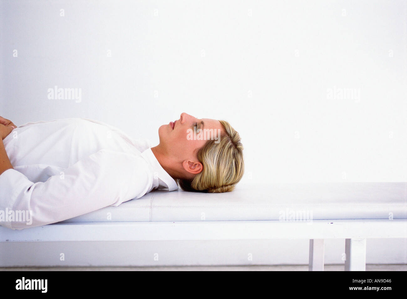 Female lying down on bench Stock Photo - Alamy