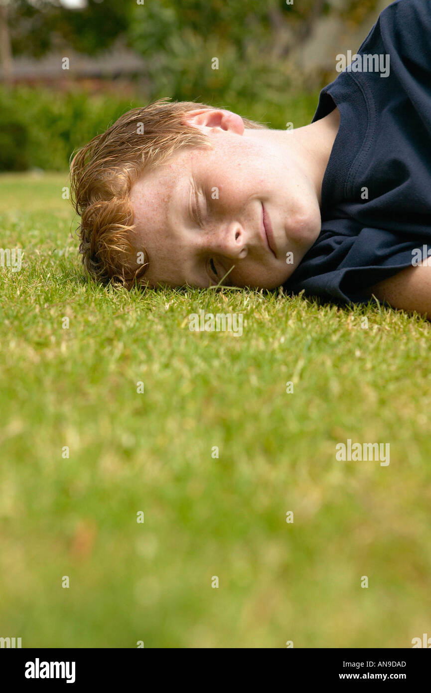 Smiling boy lying on the grass Stock Photo - Alamy