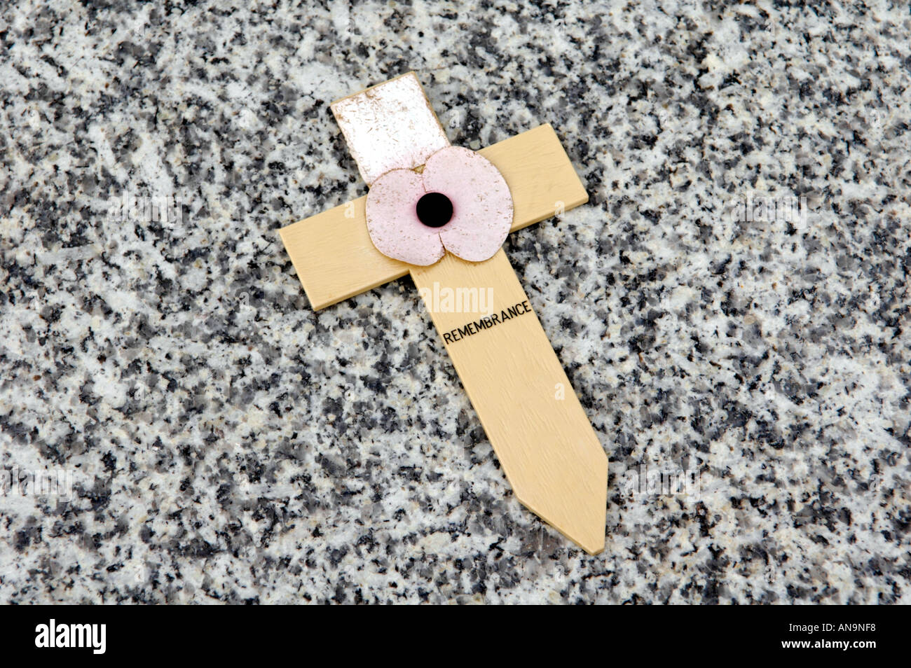 Wooden cross of remembrance with faded poppy on War memorial in UK ...