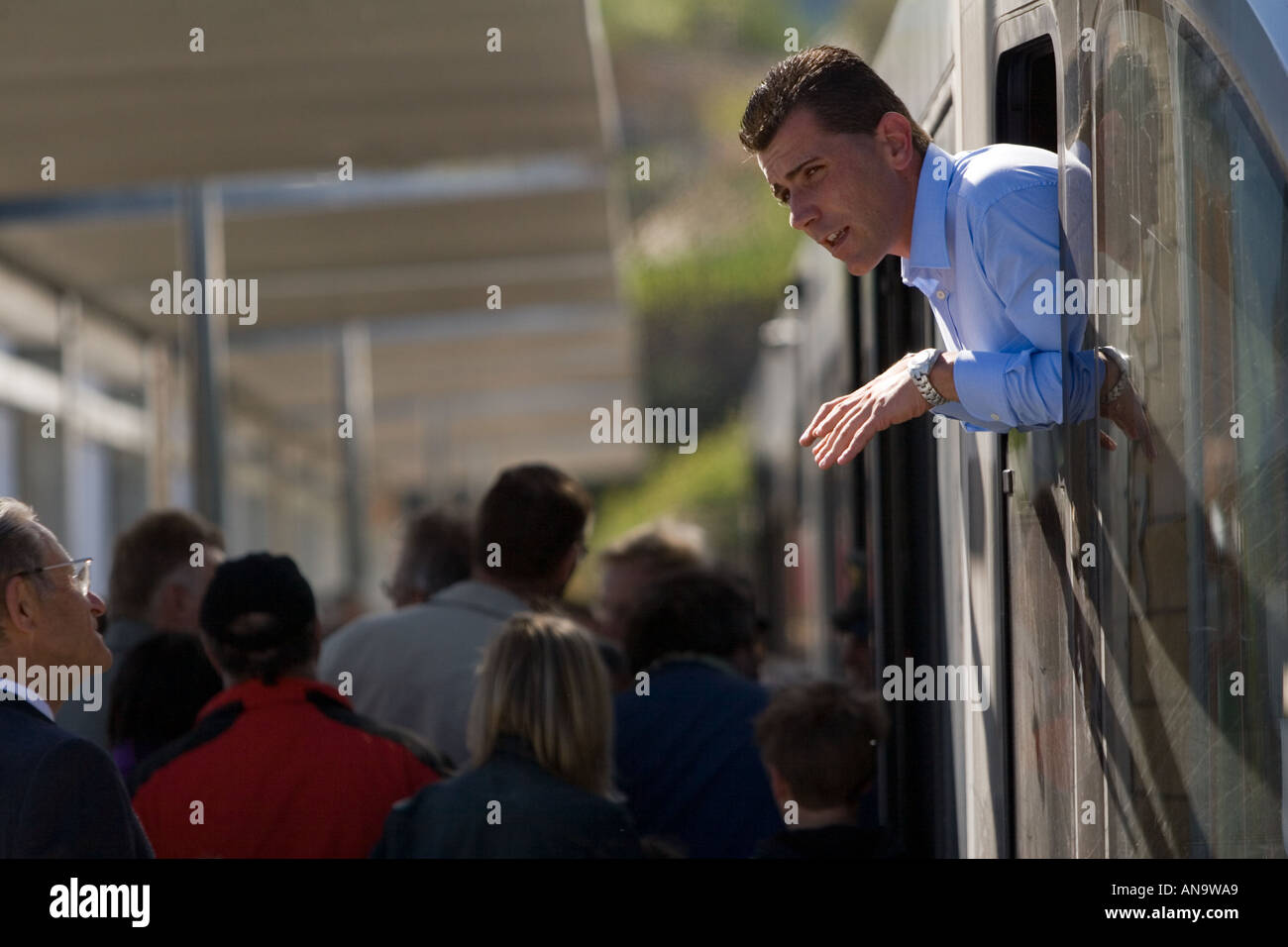Italian train driver leaning out of his cab window and is talking to a ...