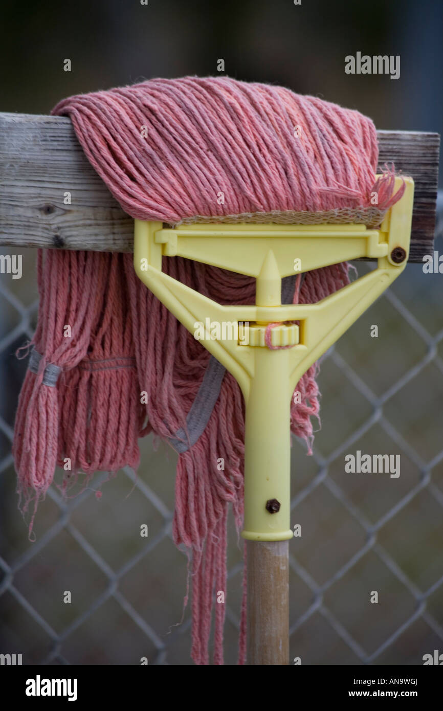Mops hanging on fence to dry Stock Photo - Alamy