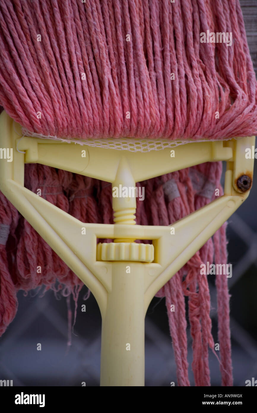 Mops hanging on fence to dry Stock Photo - Alamy