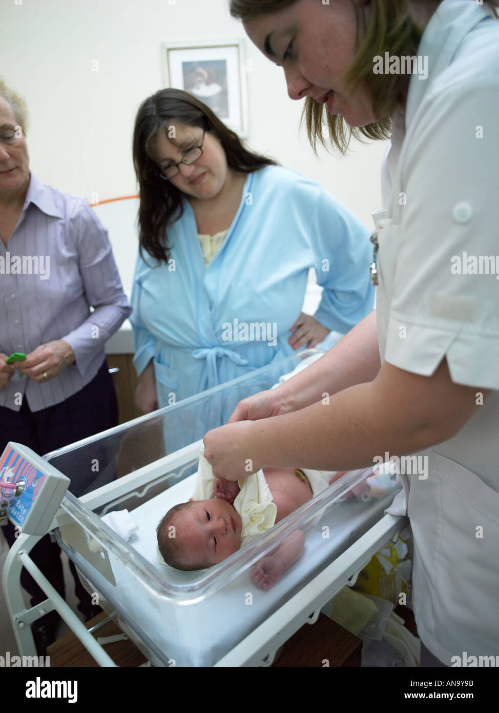 new mother being shown how to change babies clothes Stock Photo - Alamy
