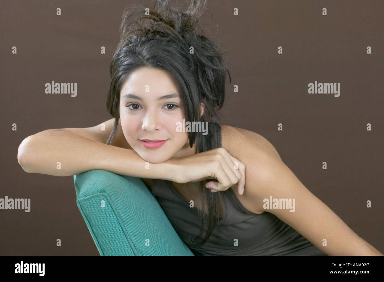 Hispanic girl resting chin on arm Stock Photo - Alamy