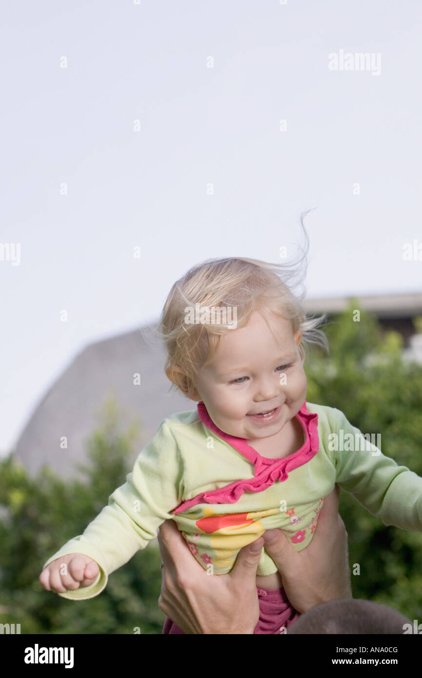 Baby being held up outdoors Stock Photo - Alamy