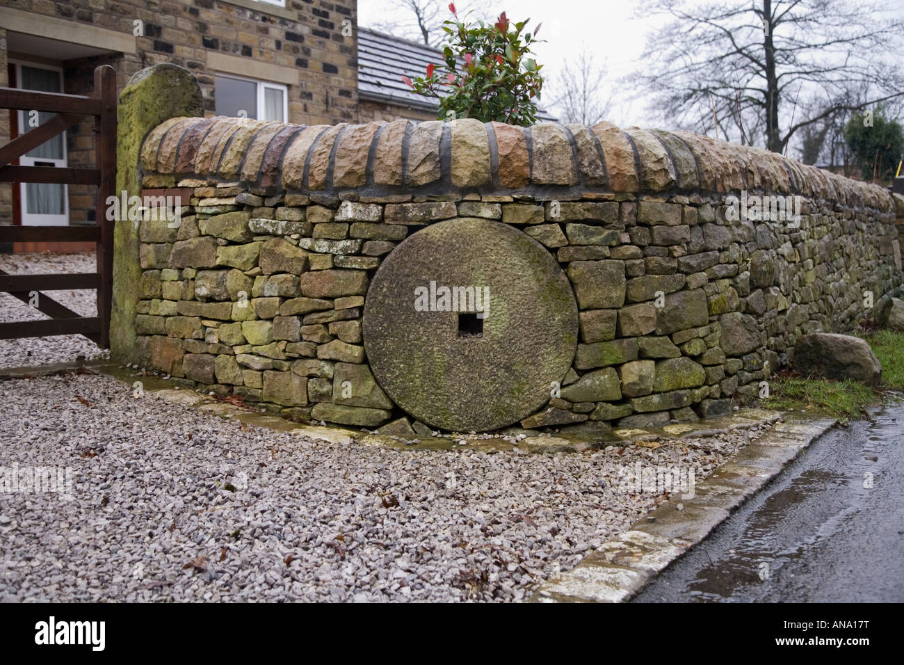 A dry stone wall and millstone / grind stone incorporated into it ...