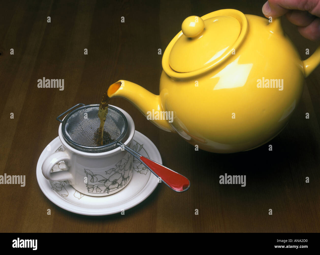 pouring tea from a teapot through a strainer Stock Photo - Alamy