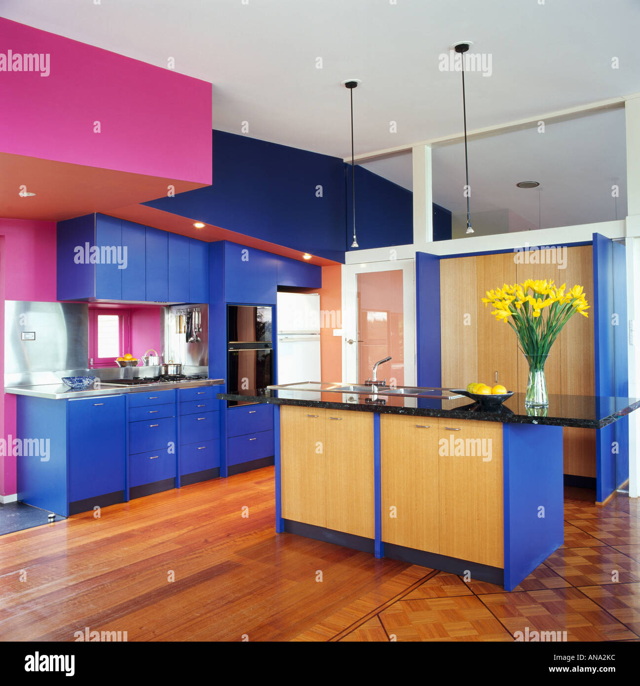 Island unit in spacious fuchsia pink and bright blue kitchen with ...