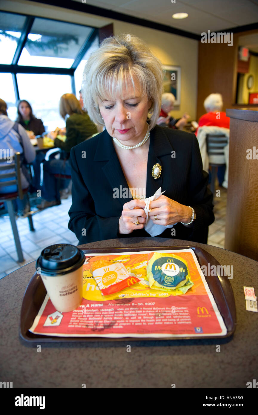 Adult professional female eating at a Fast food restaurant breakfast ...