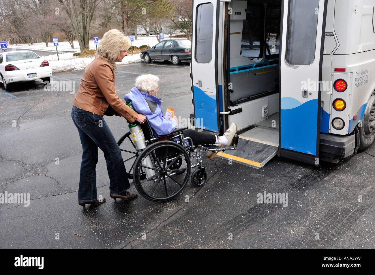 Adult female daughter helping handicapped senior mother in wheelchair ...