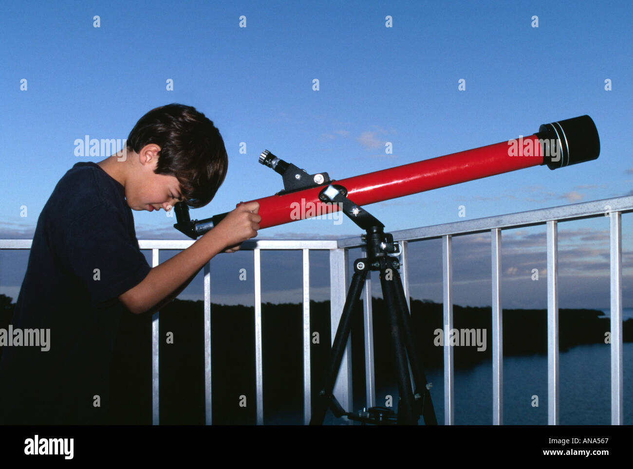Boy looking through a telescope Stock Photo - Alamy