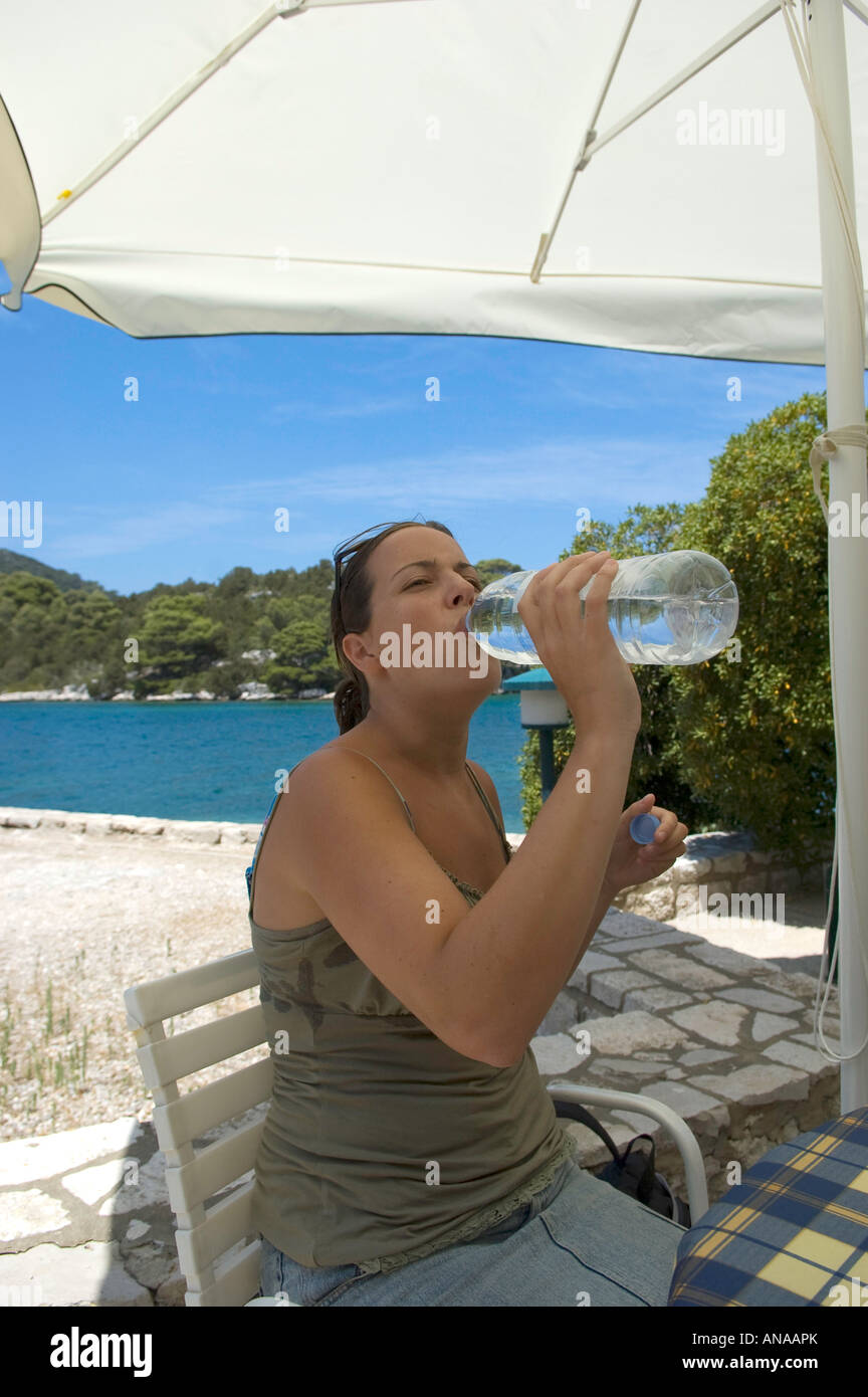 Young female adult drinking water from a bottle Stock Photo - Alamy