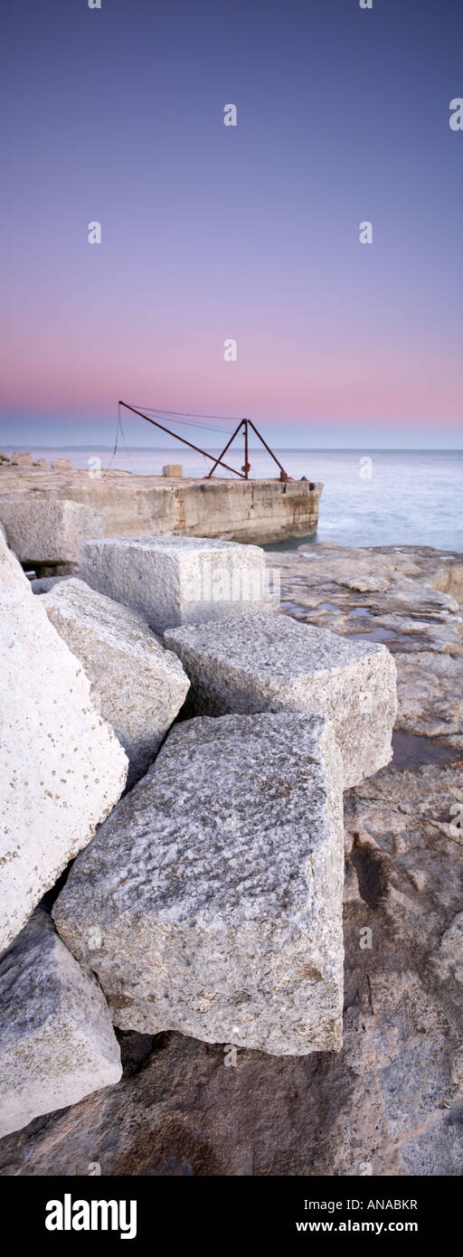 Large quarried stone blocks and rusty red crane near Portland Bill ...