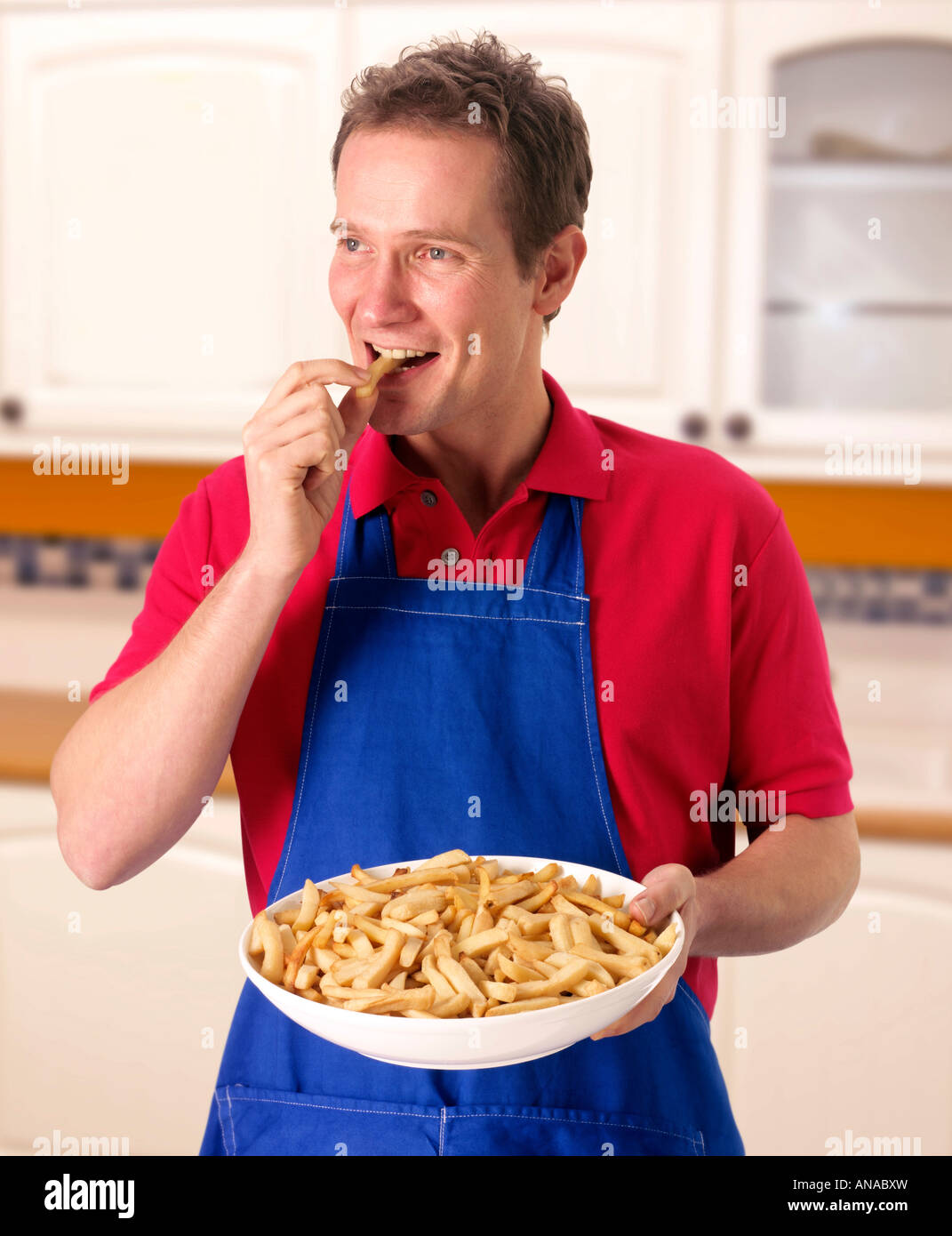 MAN IN KITCHEN WITH BOWL OF FRENCH FRIES Stock Photo - Alamy
