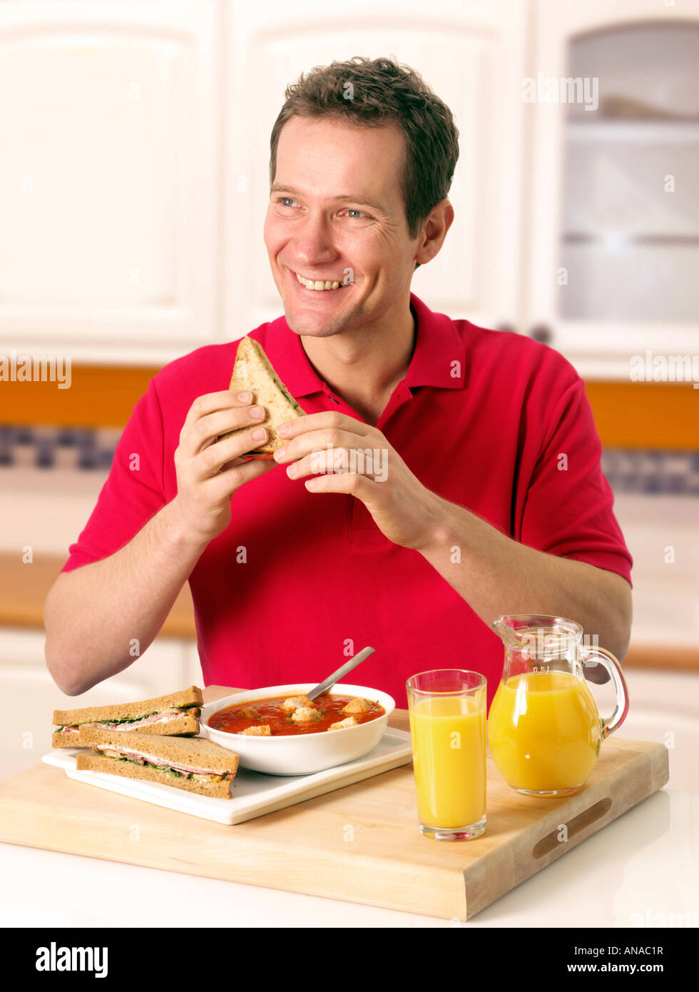 MAN IN KITCHEN EATING LUNCH Stock Photo - Alamy