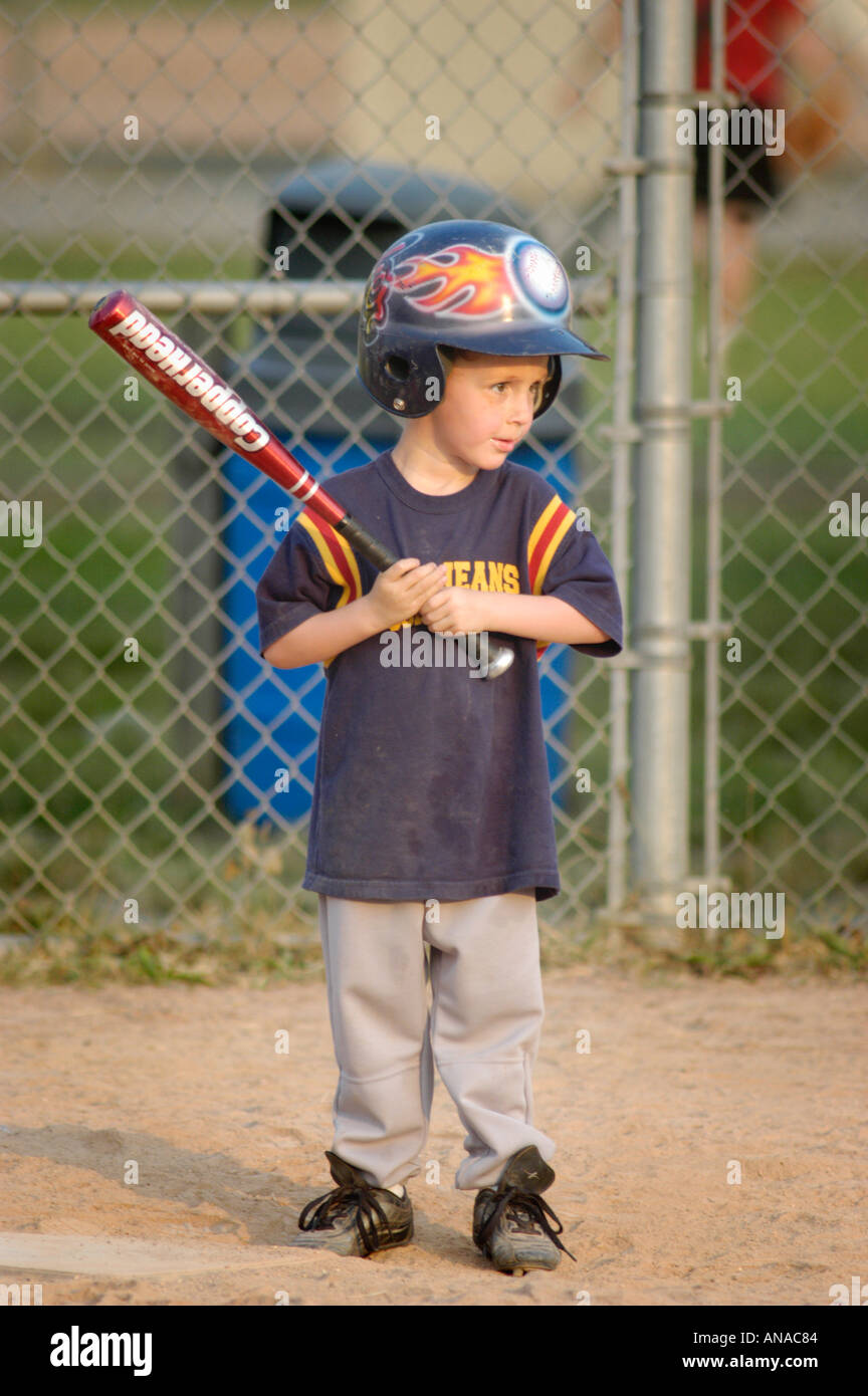 4 year old boy learning to bat in baseball safety helmet in little ...
