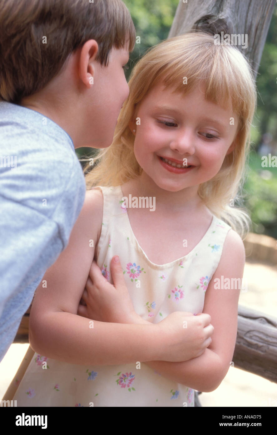 Children Boy tells girl a secret Stock Photo - Alamy