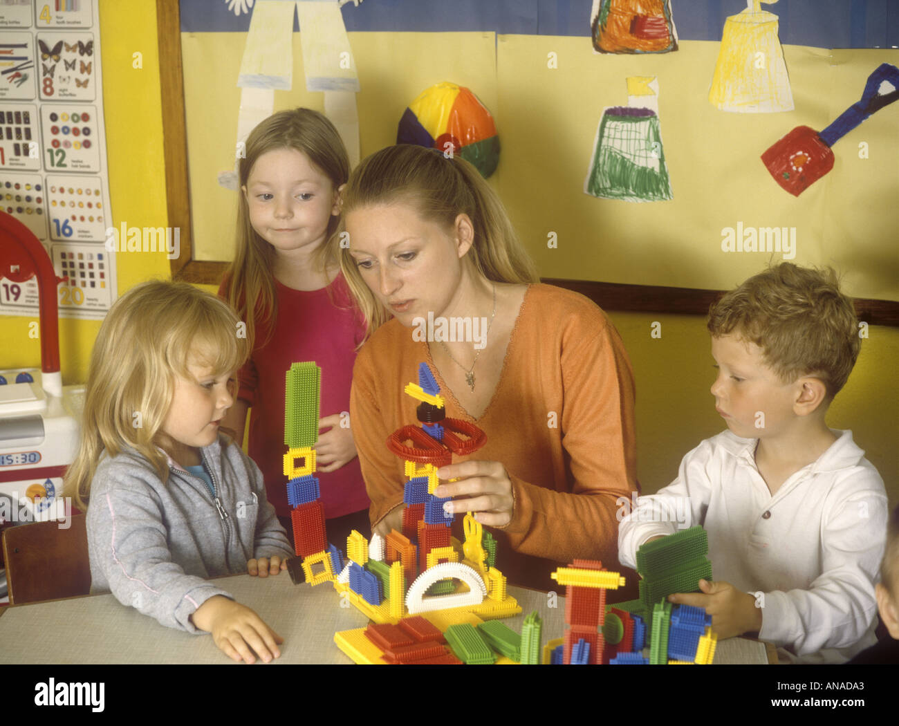 Children playing with 'Stickle Bricks' at preschool with mother helper ...