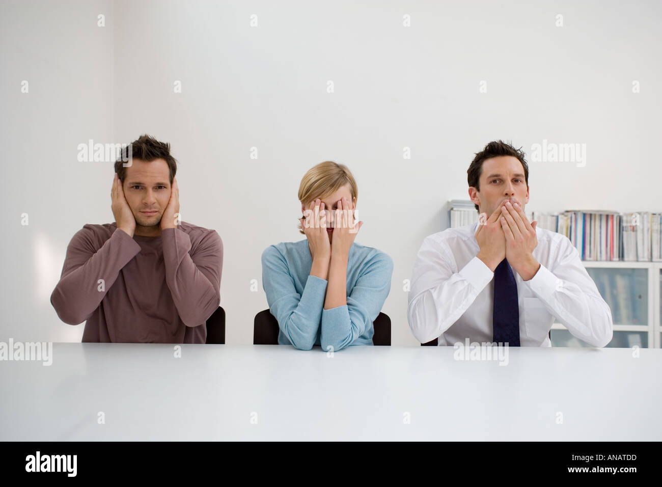 three office workers playing the three wise monkeys hear no evil see no ...