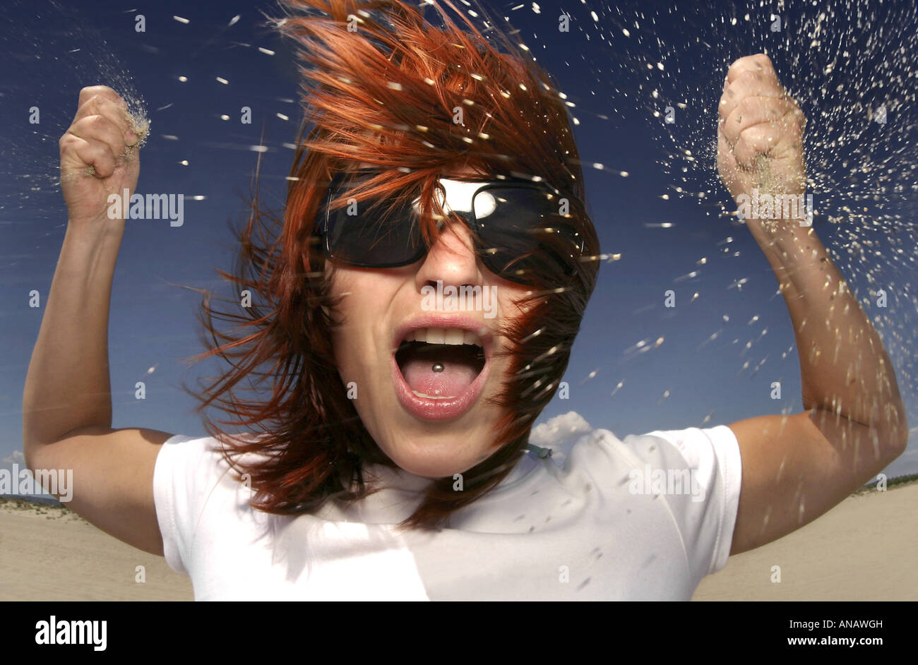 crazy young redheaded woman slipping sand through her fingers Stock ...