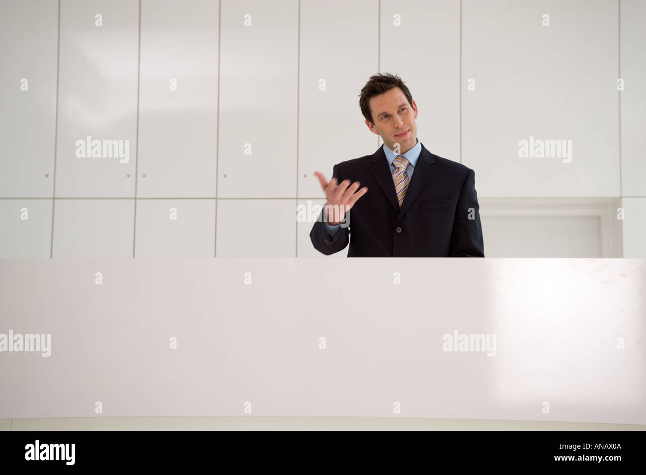 male receptionist making a welcoming gesture with his hand Stock Photo ...