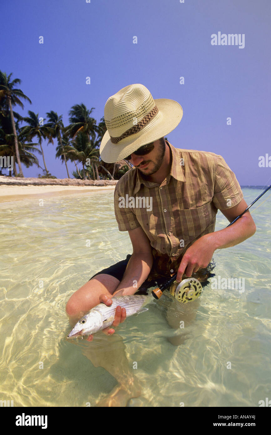 Bonefishing. Angler with captured bonefish in the sea, Belize Stock ...