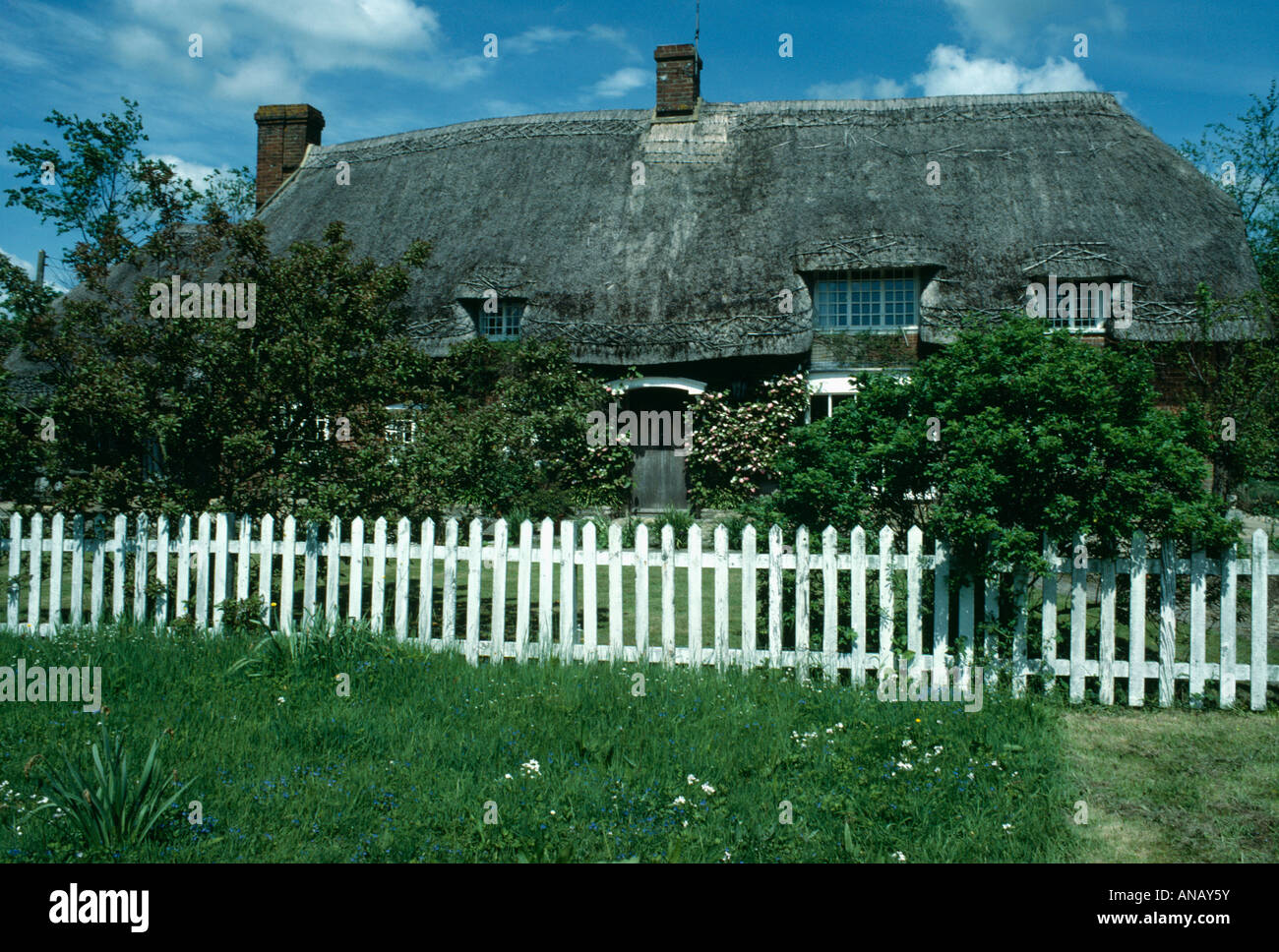 White picket fence in front of country cottage with thatched roof Stock ...