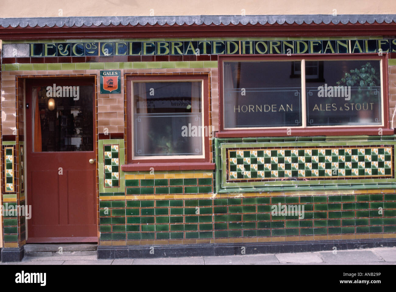Exterior of traditional Public House with green tiled wall below window ...