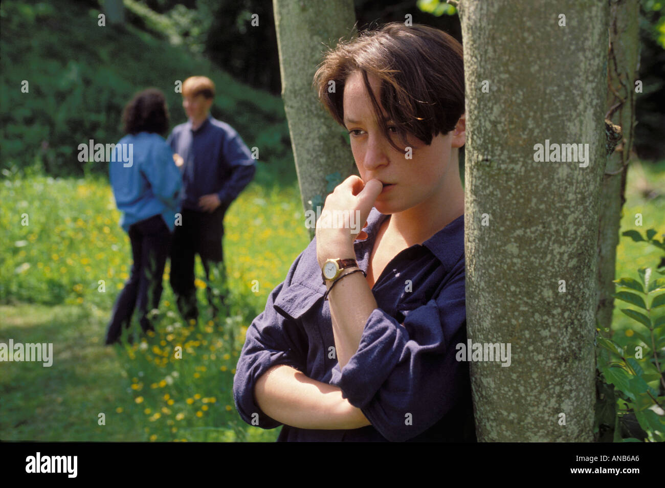 Thoughtful teenage girl with flirting friends in b g Stock Photo - Alamy