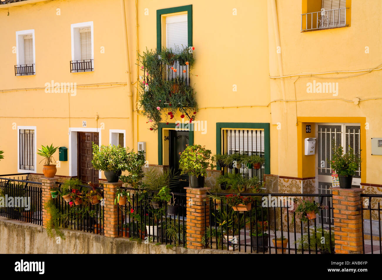 Terraced row of traditional Spanish houses painted yellow Stock Photo ...