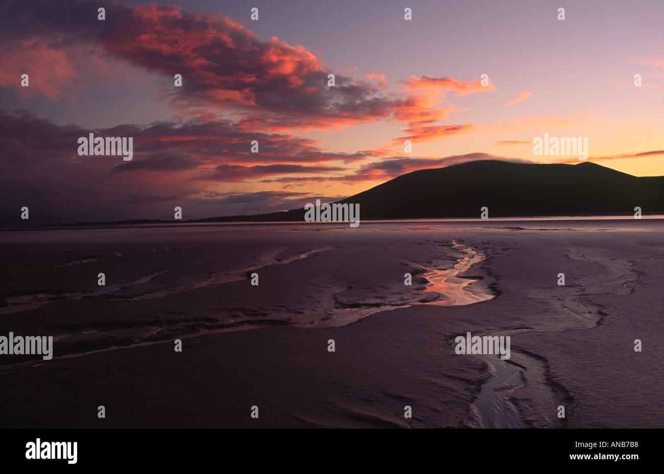 Sunset behind Criffel reflected on the mudflats of the Nith Estuary at ...