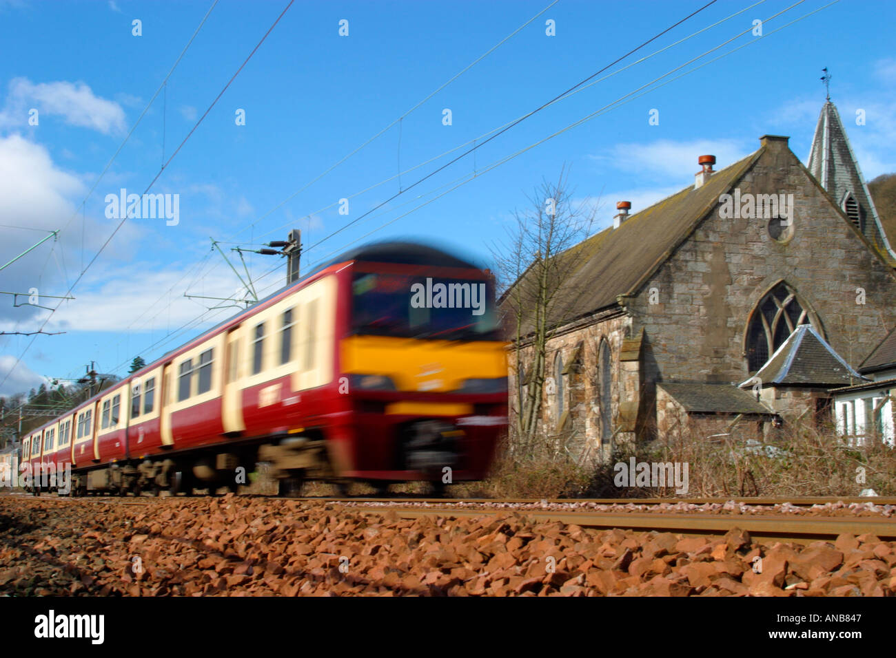 Motion blur electric suburban line train passing church Stock Photo - Alamy