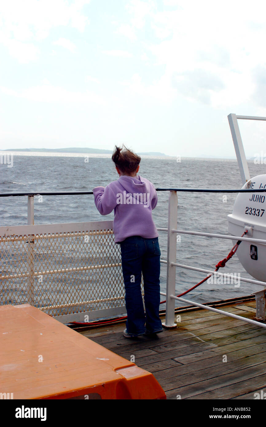 Young girl looking out to sea over boat rail Stock Photo - Alamy