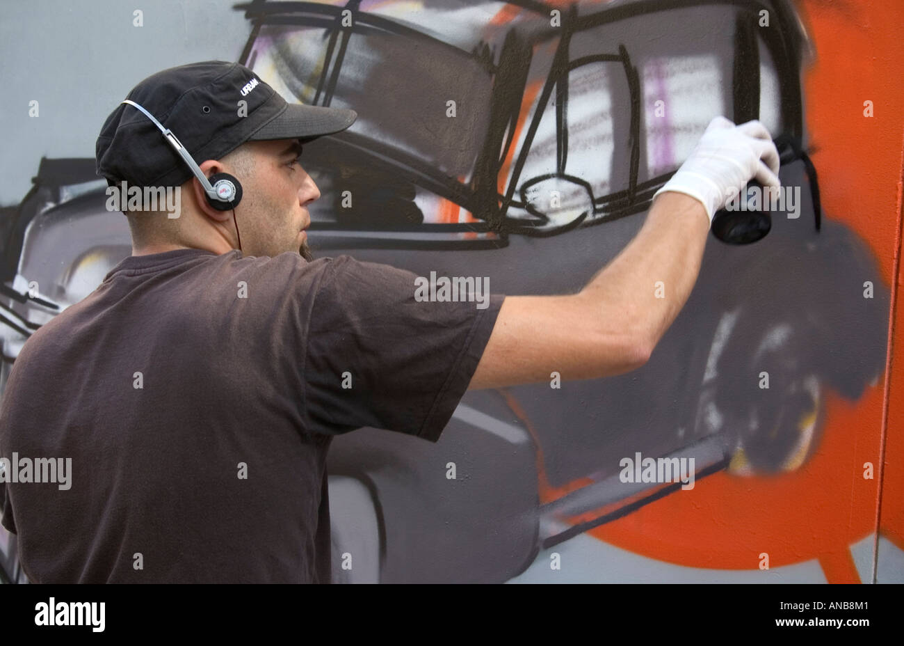 Teen Graffiti artist painting while listening to music Stock Photo - Alamy