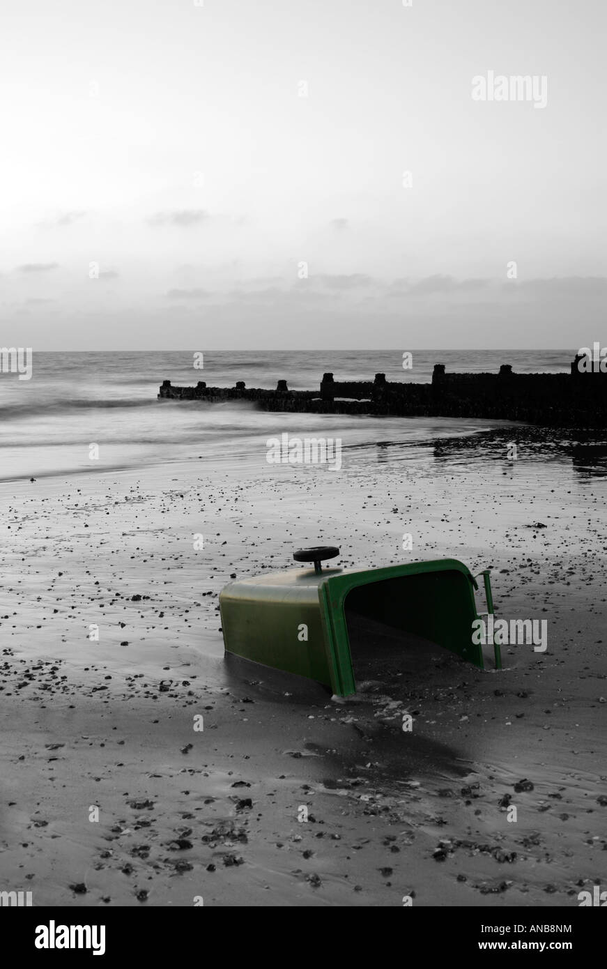 Green waste bin littering a clean beach Stock Photo - Alamy
