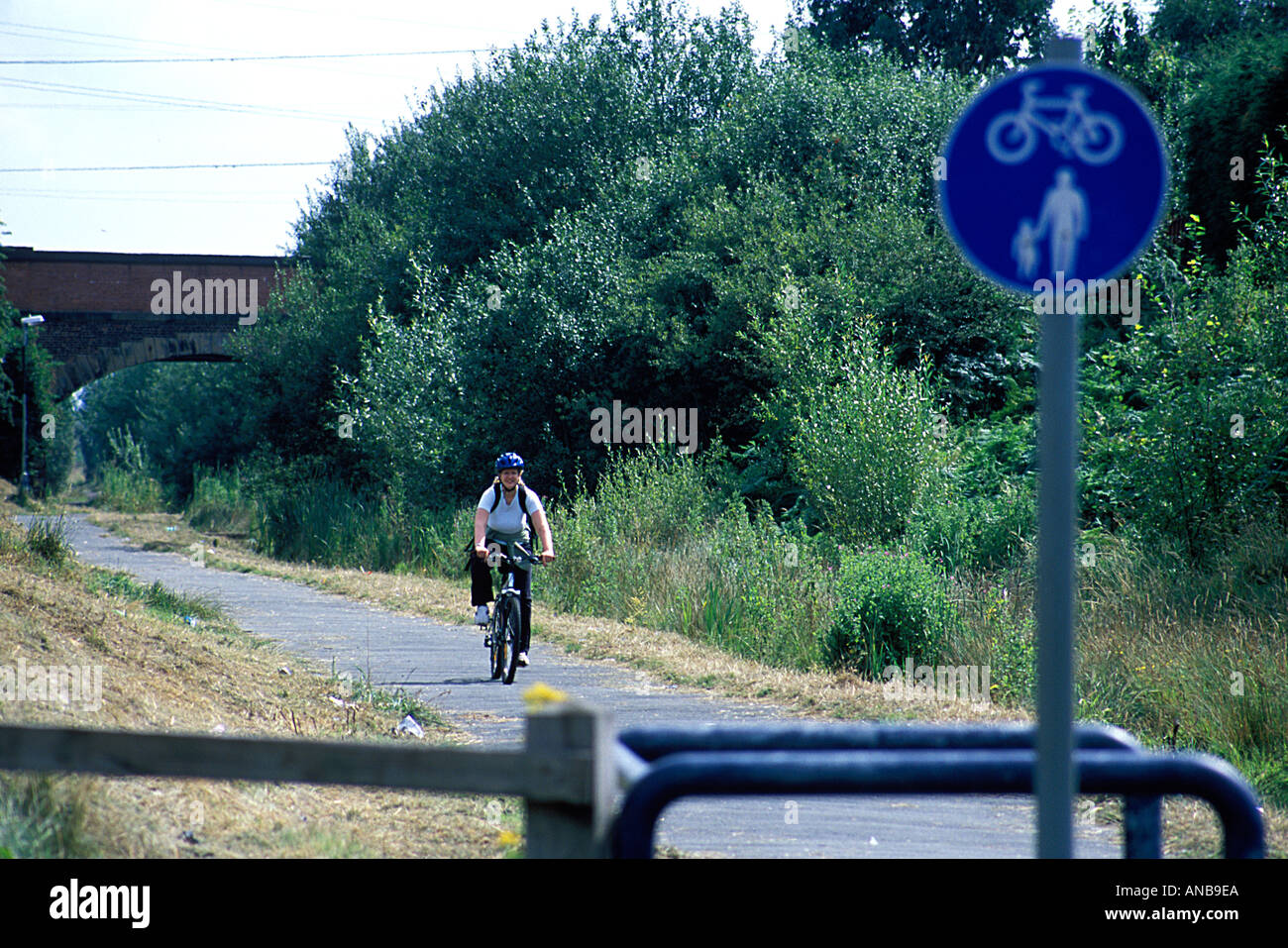 Woman cyclist cycles enthusiastically down a designated cycle track ...