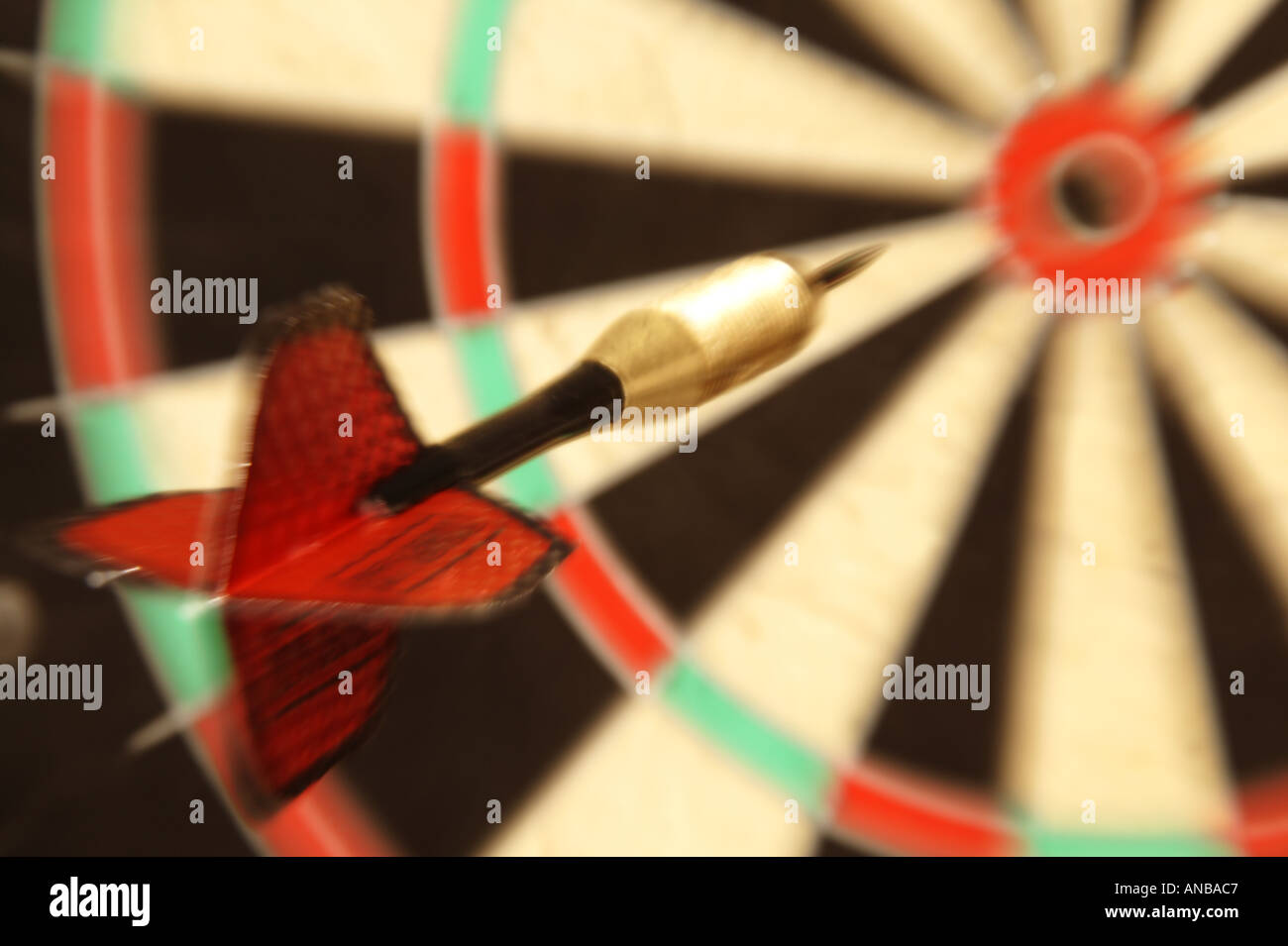 A dart in flight with dartboard behind Stock Photo - Alamy
