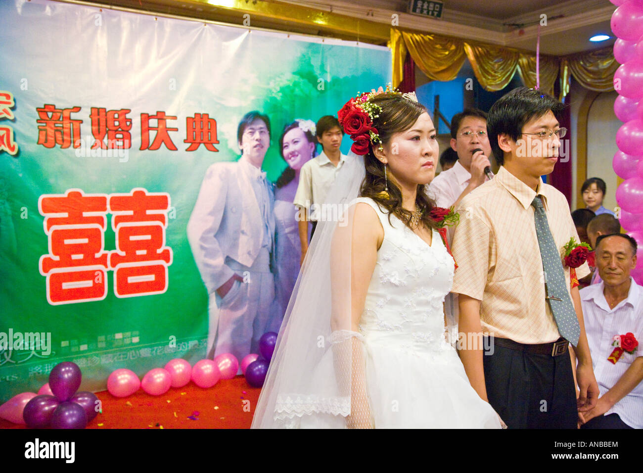 Bride and groom at asian oriental Chinese wedding with large photograph ...