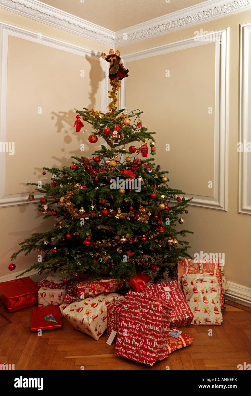Christmas Tree With Presents and Angel on Top in Lounge Stock Photo - Alamy