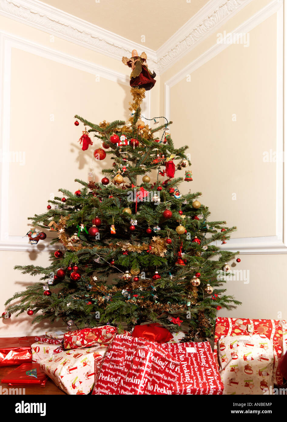 Christmas Tree With Presents and Angel on Top in Lounge Stock Photo - Alamy